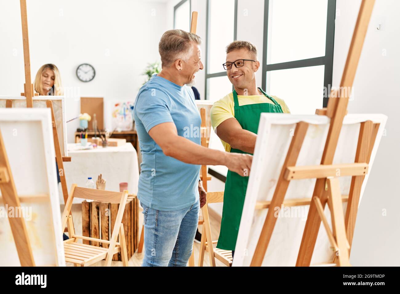 Group of middle age paint students drawing at art studio. Teacher ...