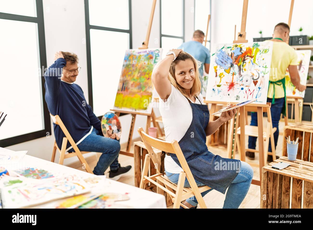 Group of middle age artist at art studio smiling confident touching ...