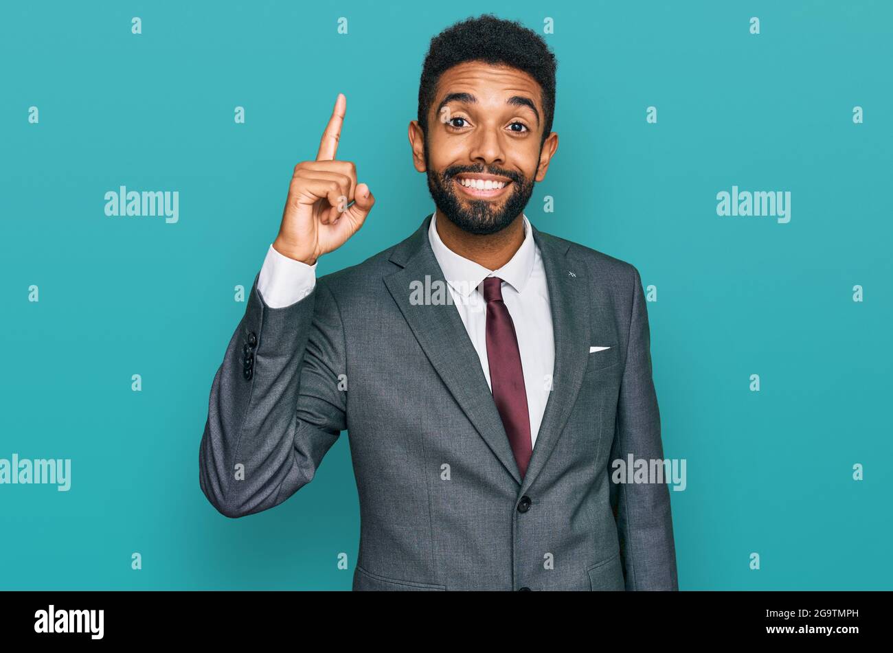 Young african american man wearing business clothes pointing finger up ...