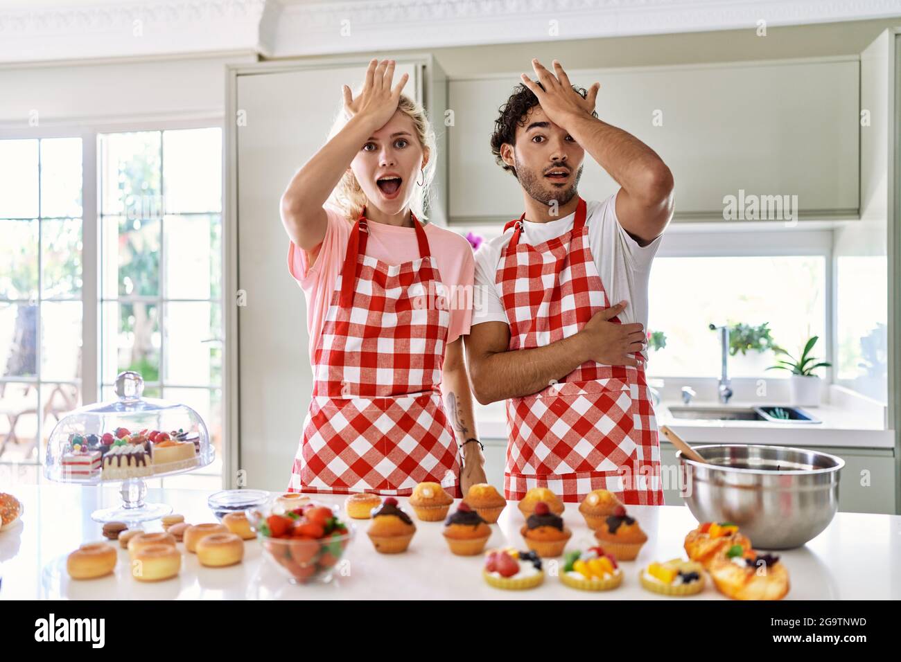 Couple of wife and husband cooking pastries at the kitchen surprised ...