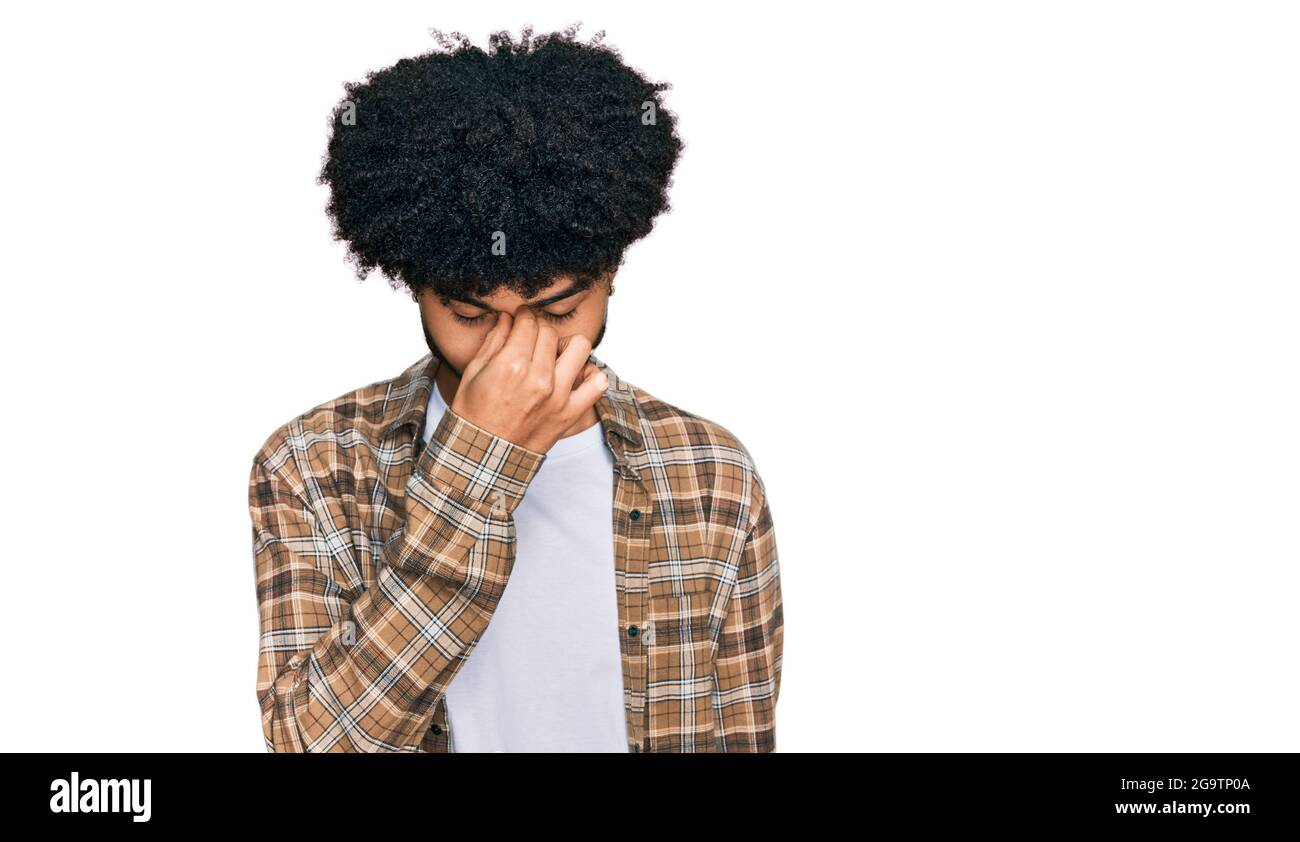 Young african american man with afro hair wearing casual clothes tired ...