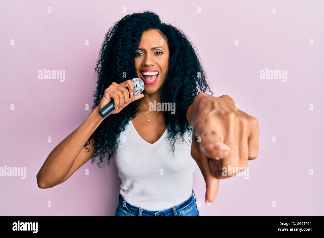 Middle age african american woman singing song using microphone ...
