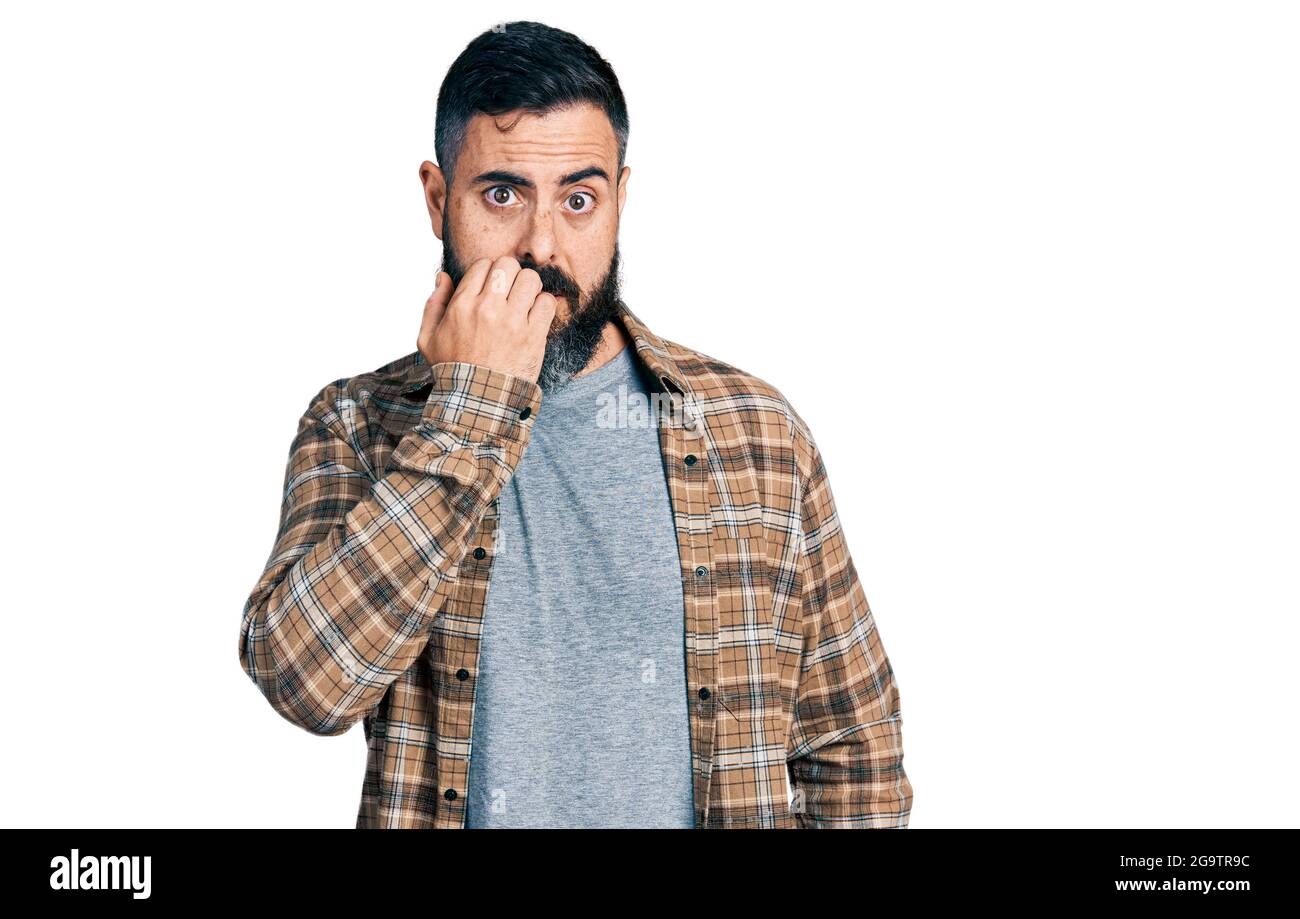 Hispanic man with beard wearing casual shirt looking stressed and ...