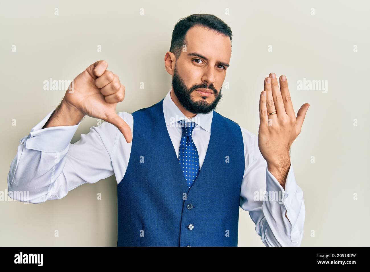 Young man with beard wearing engagement ring with angry face, negative ...