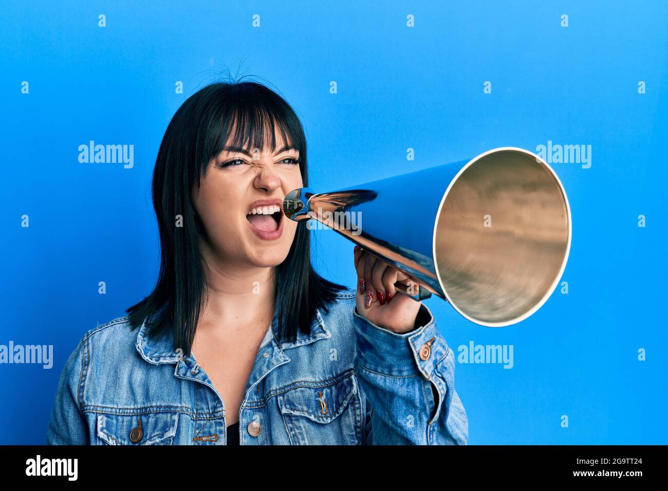 Young plus size woman shouting using megaphone Stock Photo - Alamy