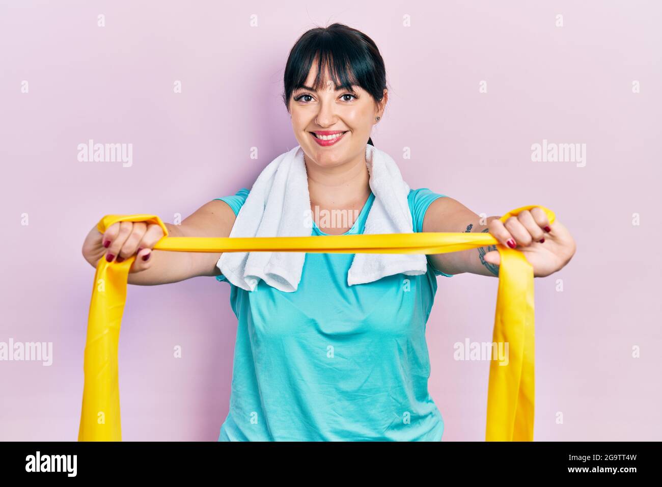 Young hispanic woman wearing sportswear and arm band smiling with a ...