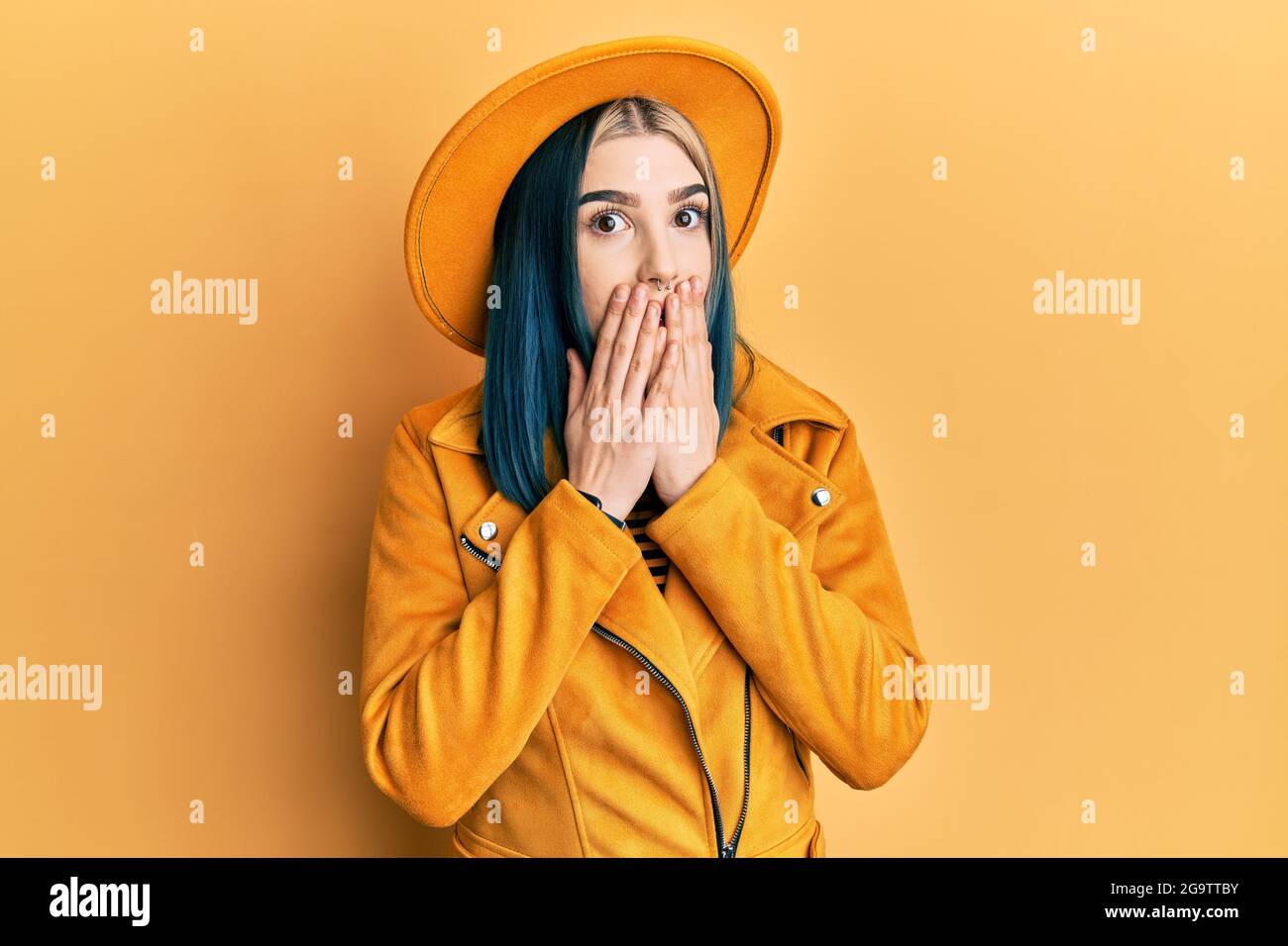Young modern girl wearing yellow hat and leather jacket laughing and ...