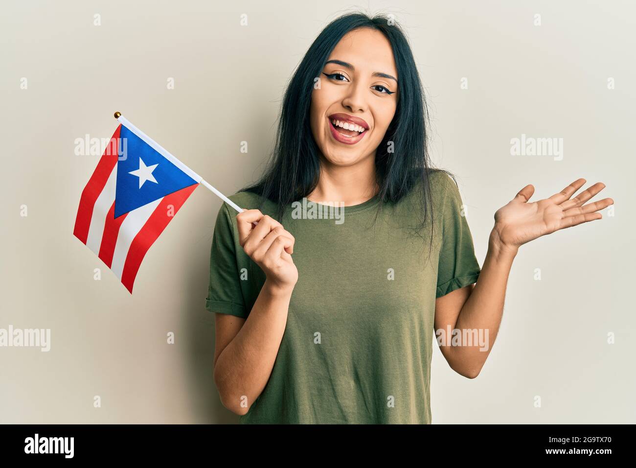 Young hispanic girl holding puerto rico flag celebrating achievement ...