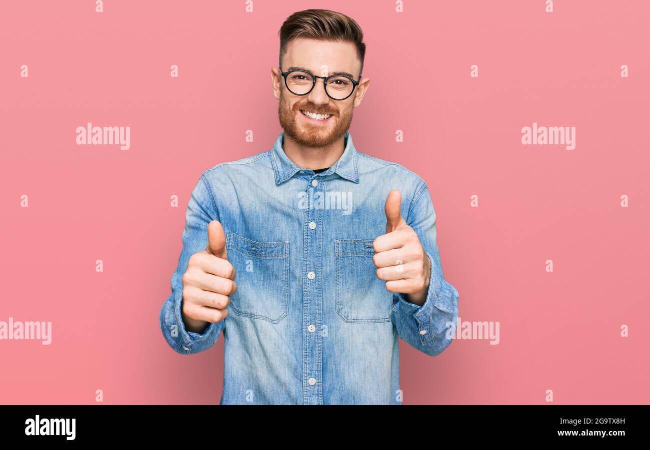 Young redhead man wearing casual denim shirt success sign doing ...