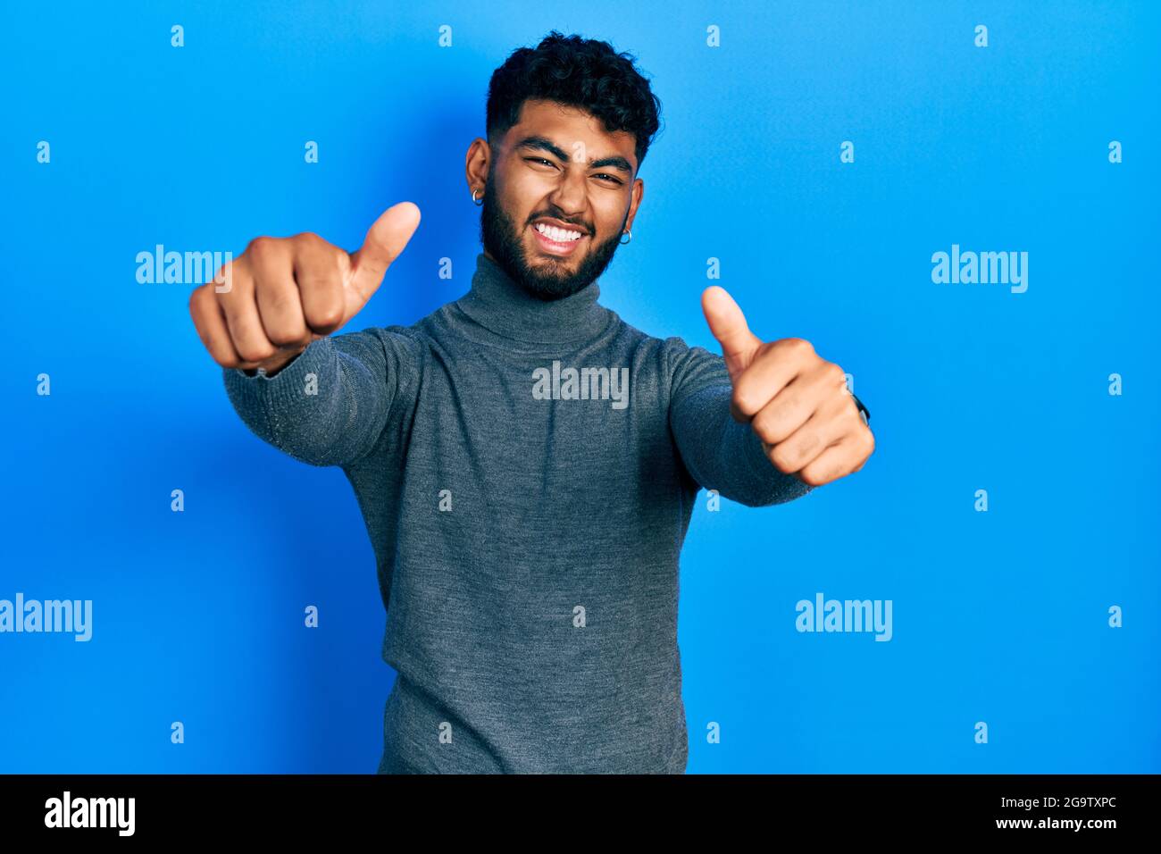 Arab man with beard wearing turtleneck sweater approving doing positive ...