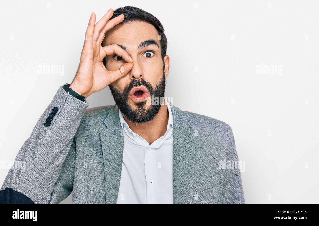 Young hispanic man wearing business clothes doing ok gesture shocked ...