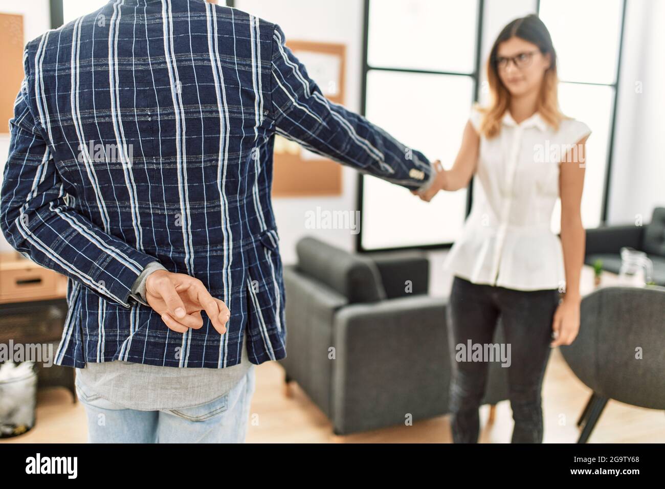 Two business workers smiling happy shaking hands. Man standing with ...