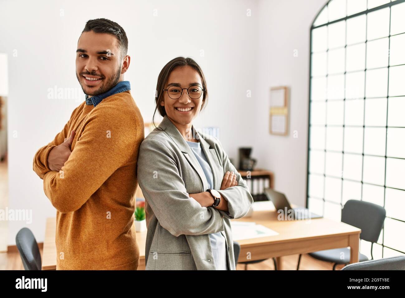 Two business workers smiling happy standing with arms crossed gesture ...