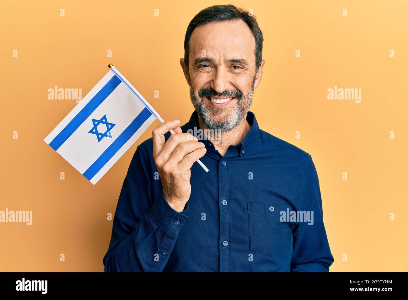 Middle age hispanic man holding israel flag looking positive and happy ...