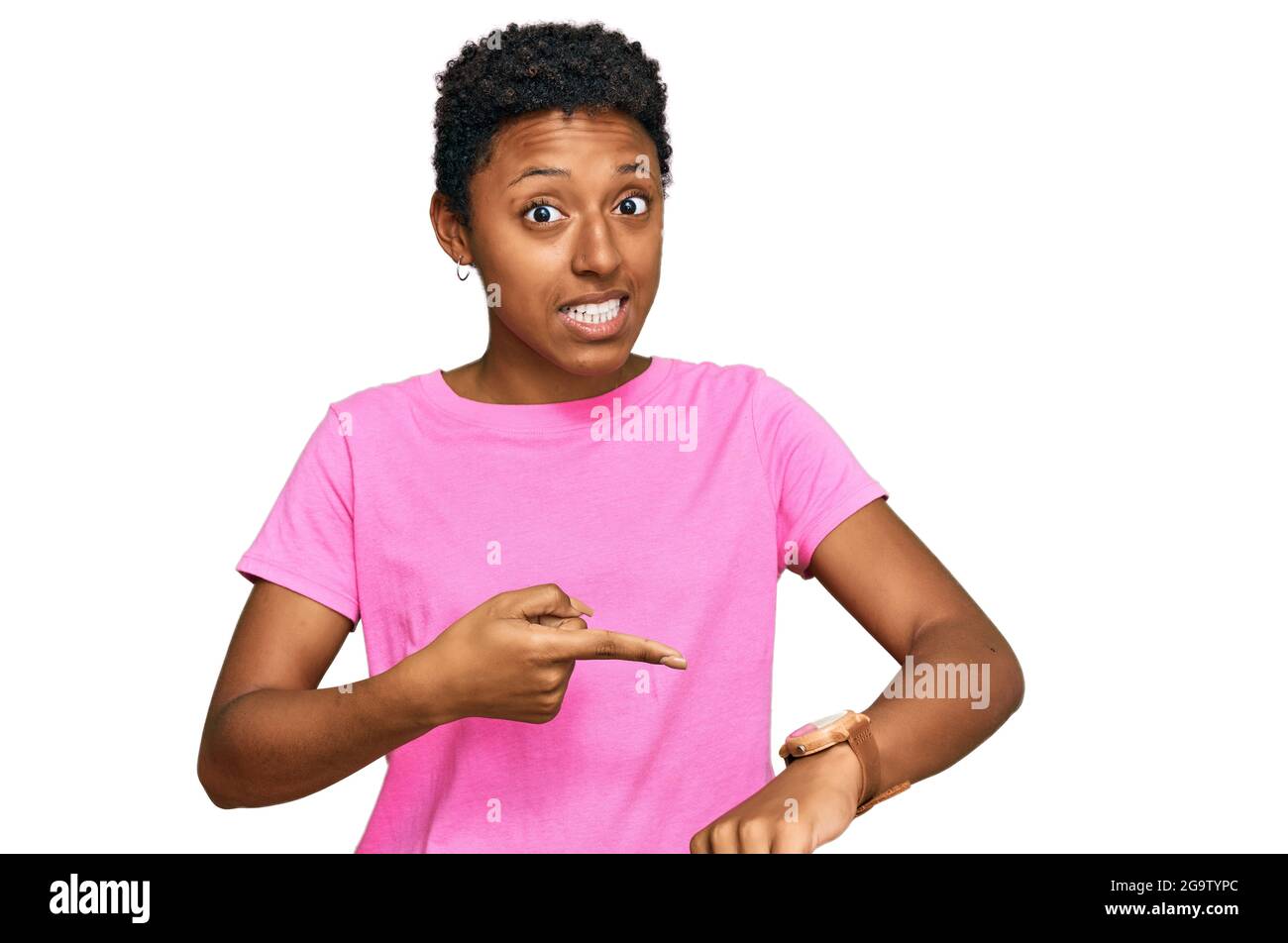 Young african american woman wearing casual clothes in hurry pointing ...
