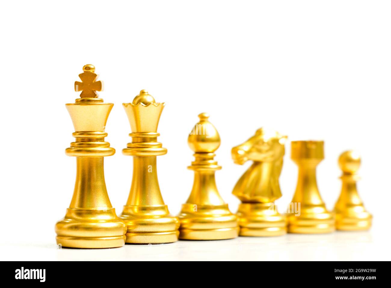 Gold chess piece stand in a row (king, queen, bishop, knight, rook ...