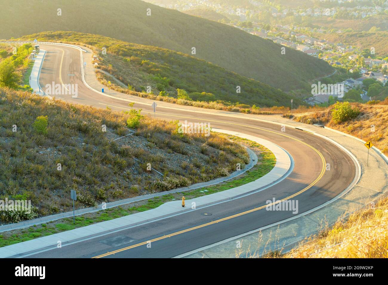 Beautiful wallpaper of an empty curving road in the countryside on a ...
