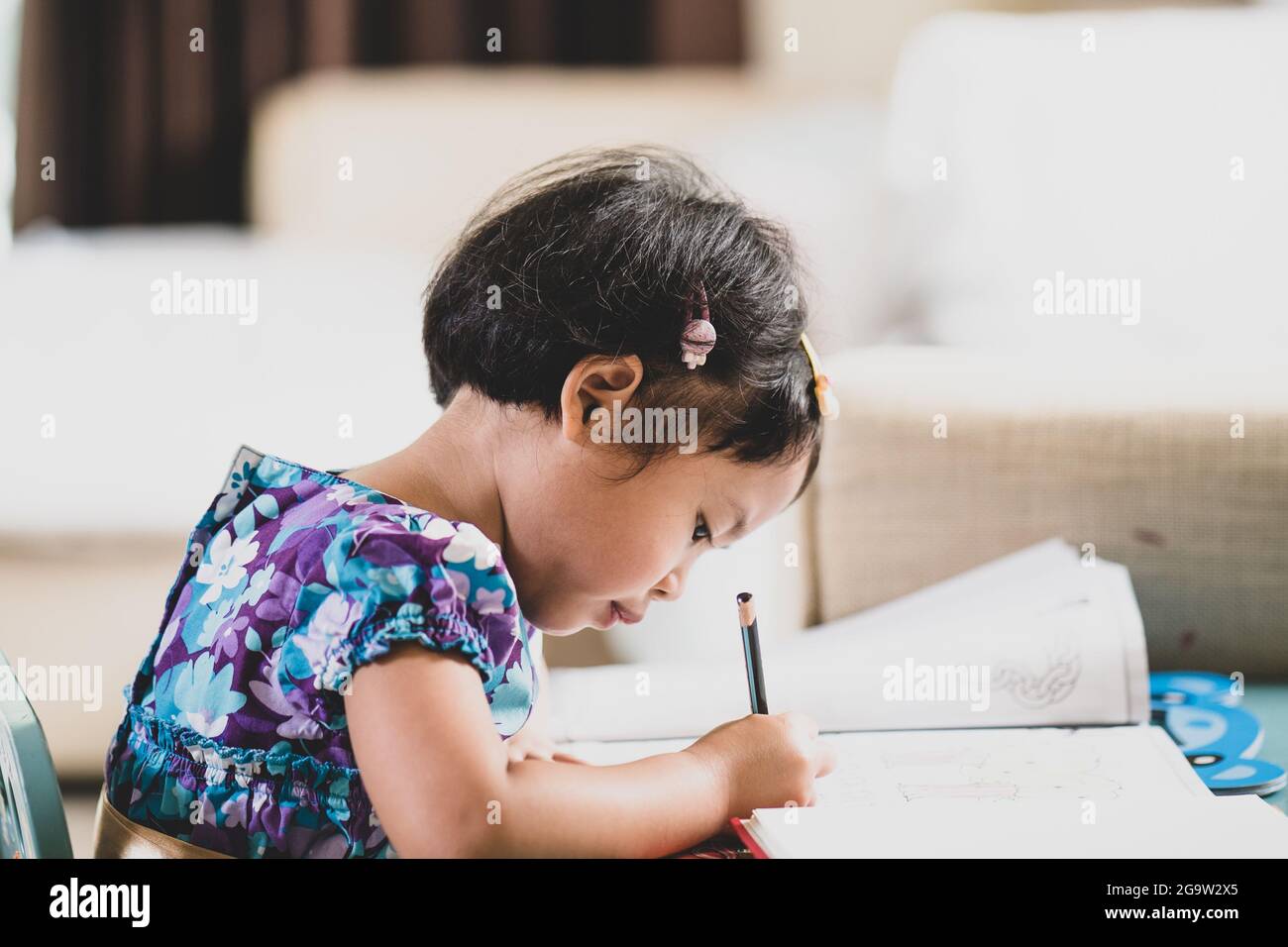 Southeast Asian female kid doing homework in the study area Stock Photo ...