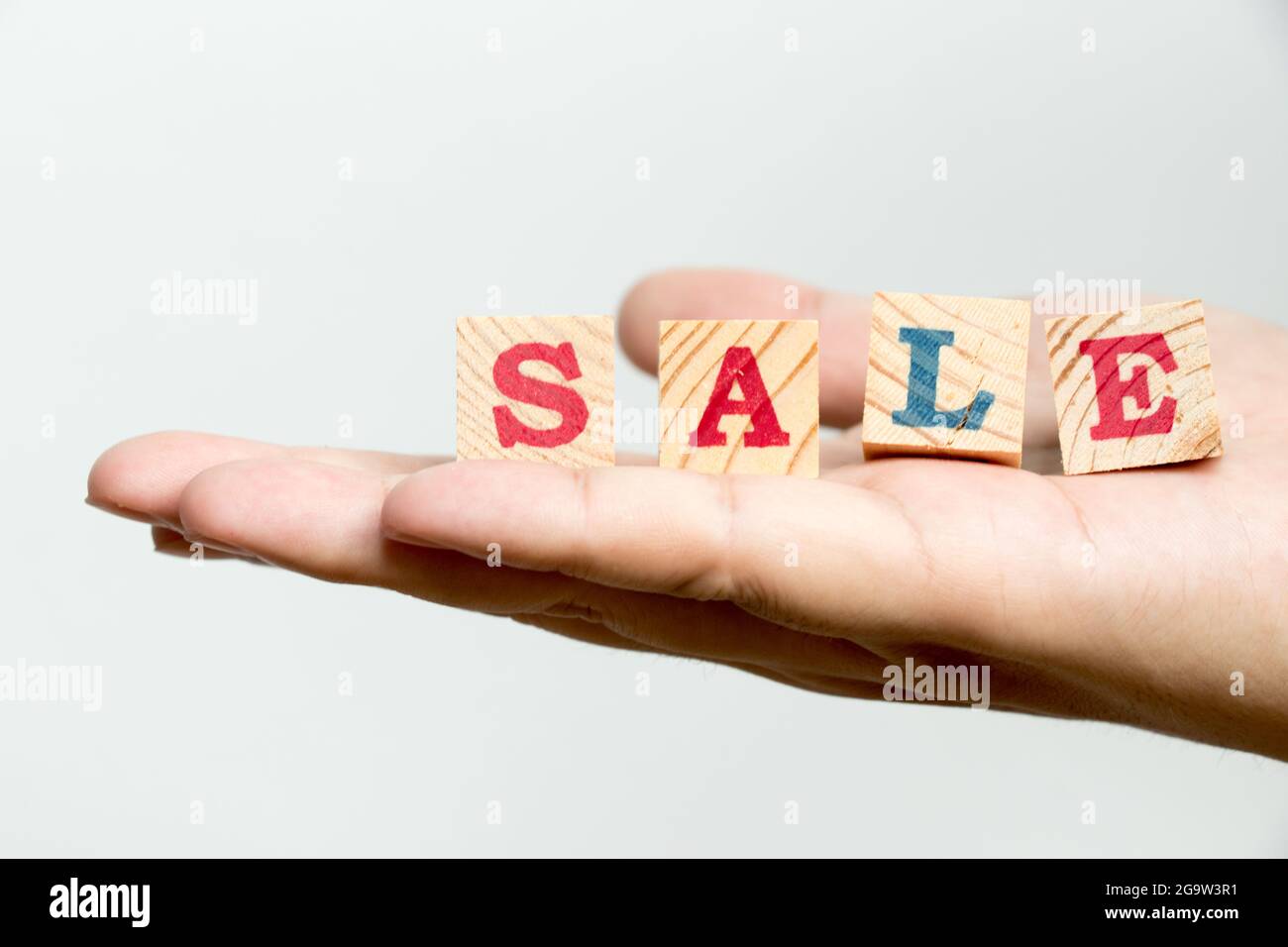 Man hold wood block with wording sale on concrete background Stock ...