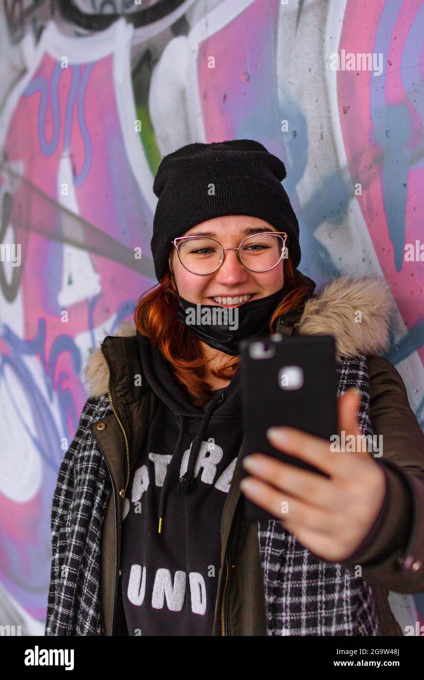 Lovely young woman receiving a video call on her mobile phone ...