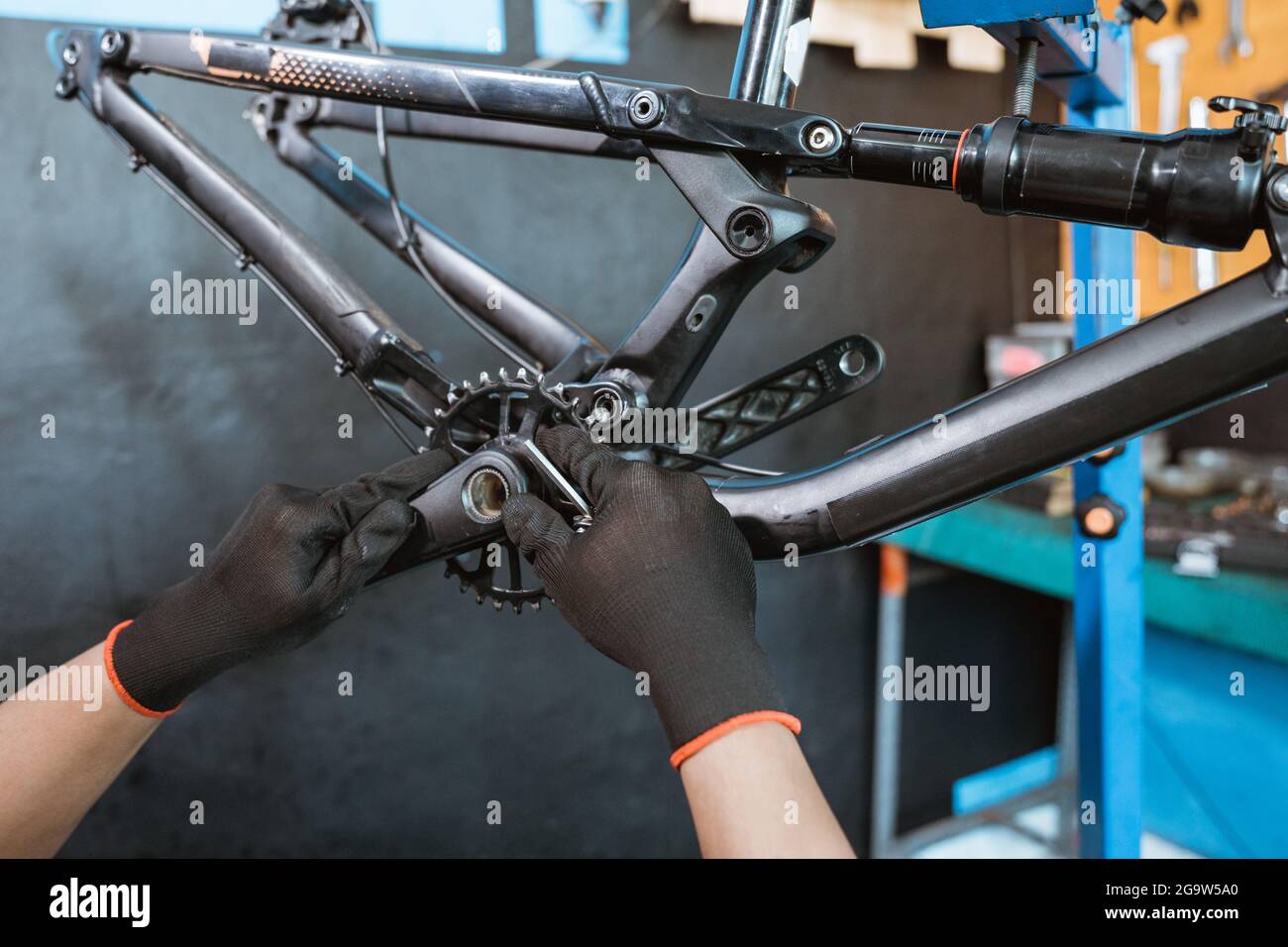 a mechanic's hand wearing gloves installing the right crank arm on the ...