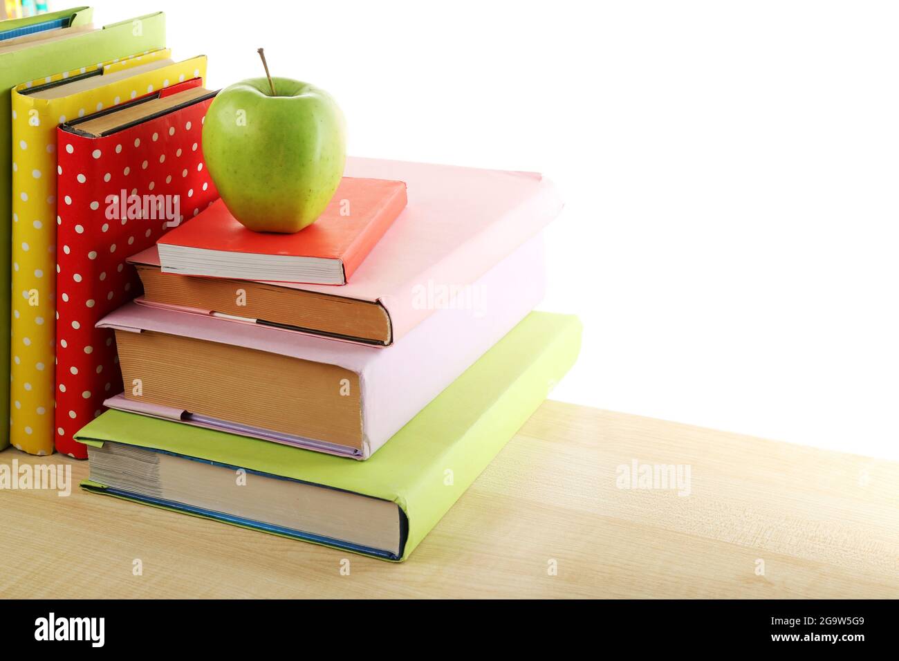 Books and apple on desk, isolated on white Stock Photo - Alamy