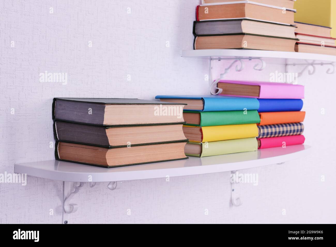 Books on shelves on white wall background Stock Photo - Alamy
