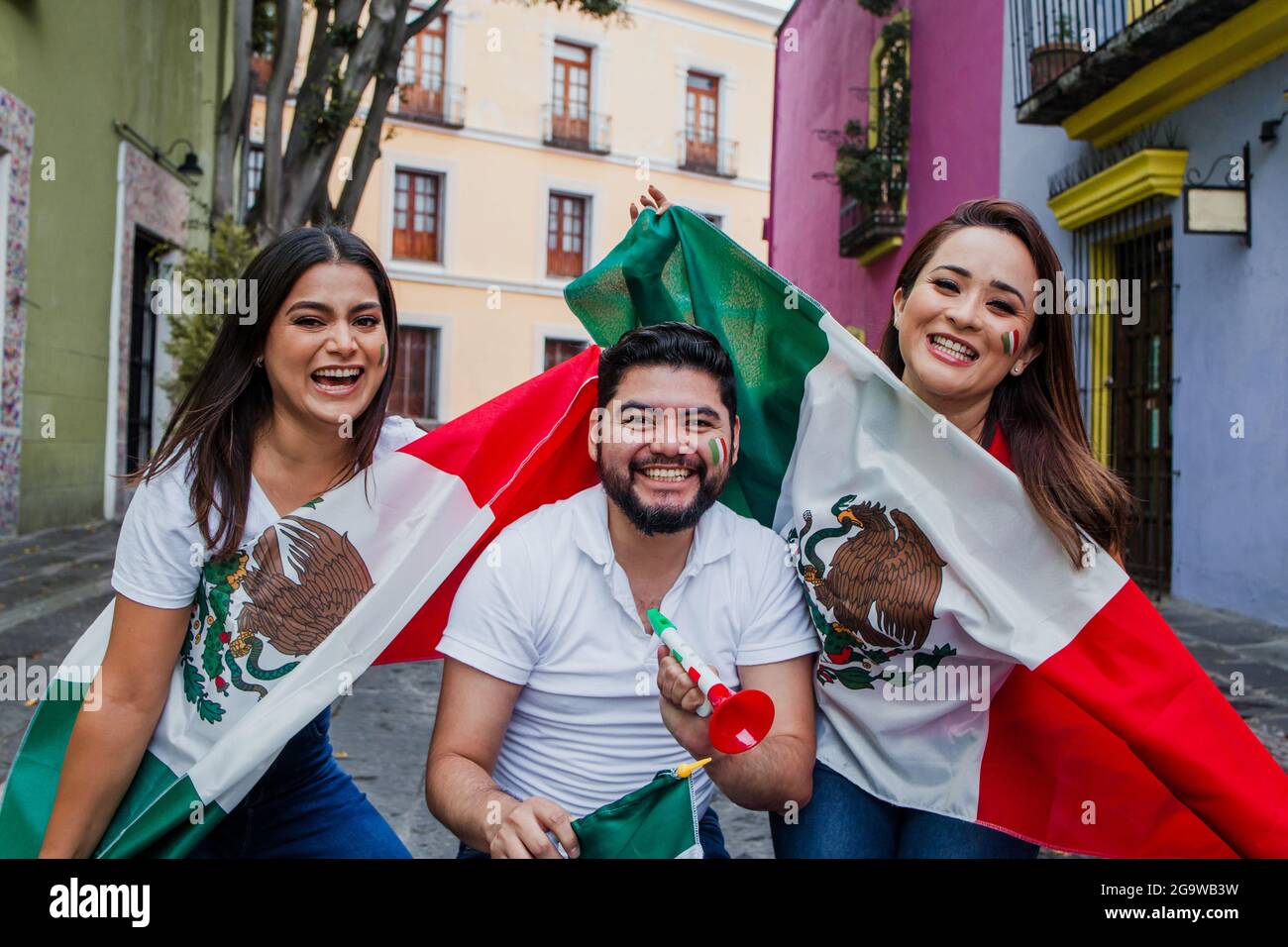 Smiling mexican people on Cinco de Mayo holding flags and trumpets in ...