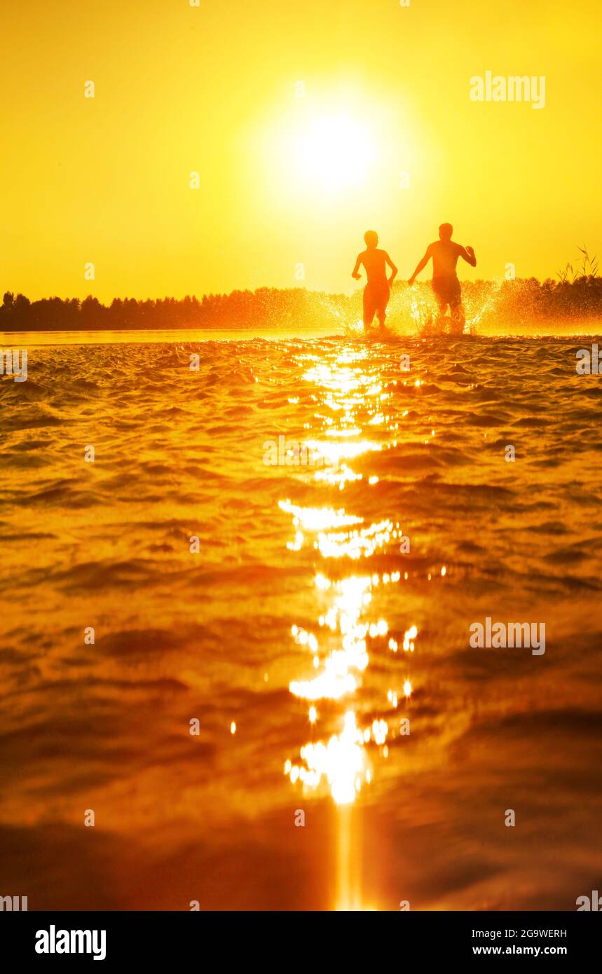 Group of young people playing games on sandy beach on a summer day ...