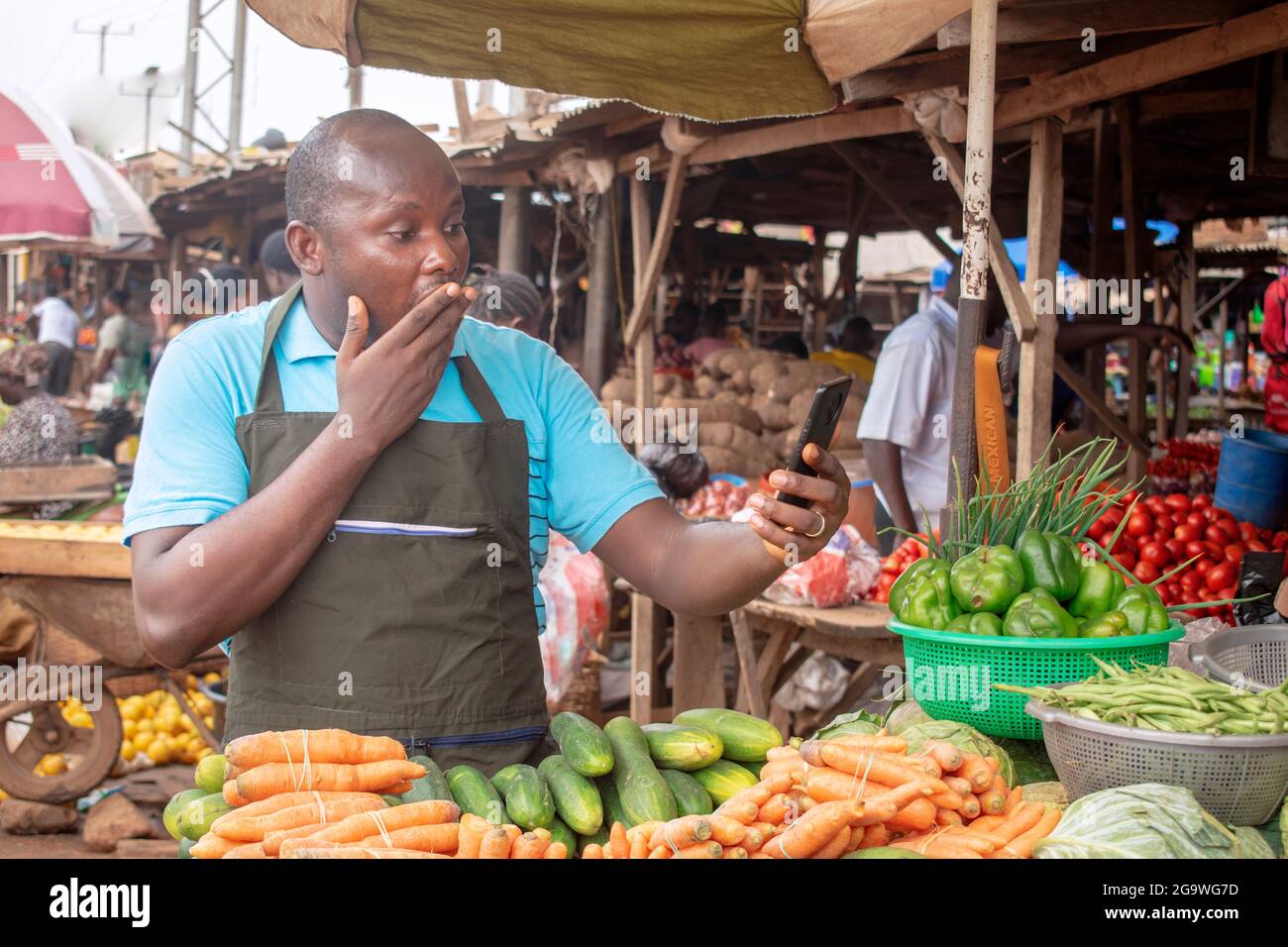 stock photo of male African grocery seller with apron, amazed as he ...