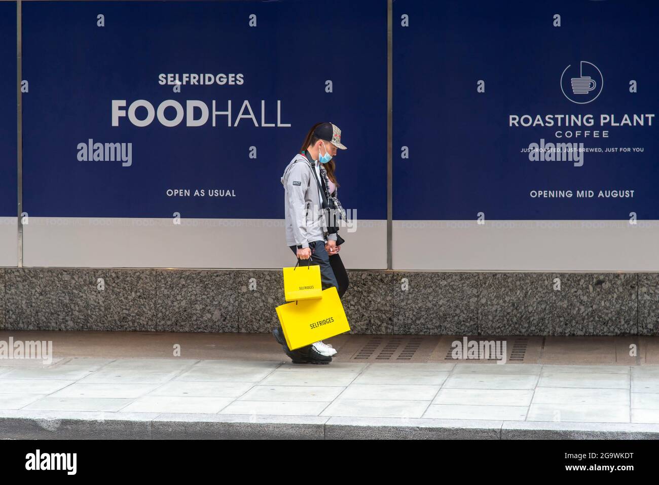 People with Selfridges bags walk past the foodhall at their flagship ...