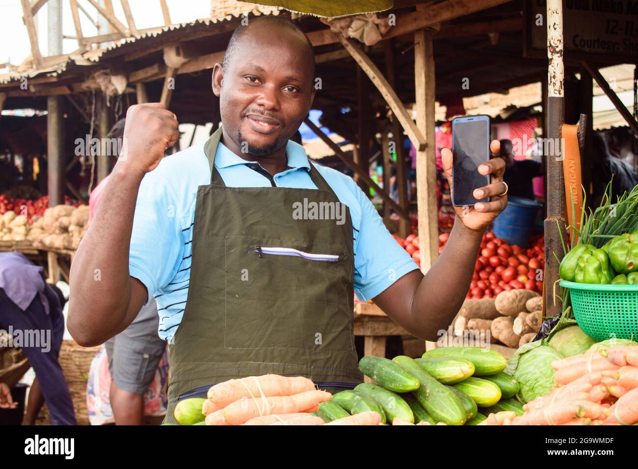 stock photo of a happy male African grocery seller with apron and smart ...