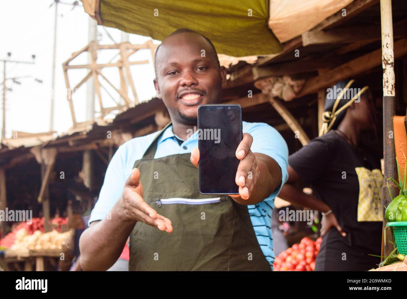 stock photo of a happy male African grocery seller with apron and smart ...