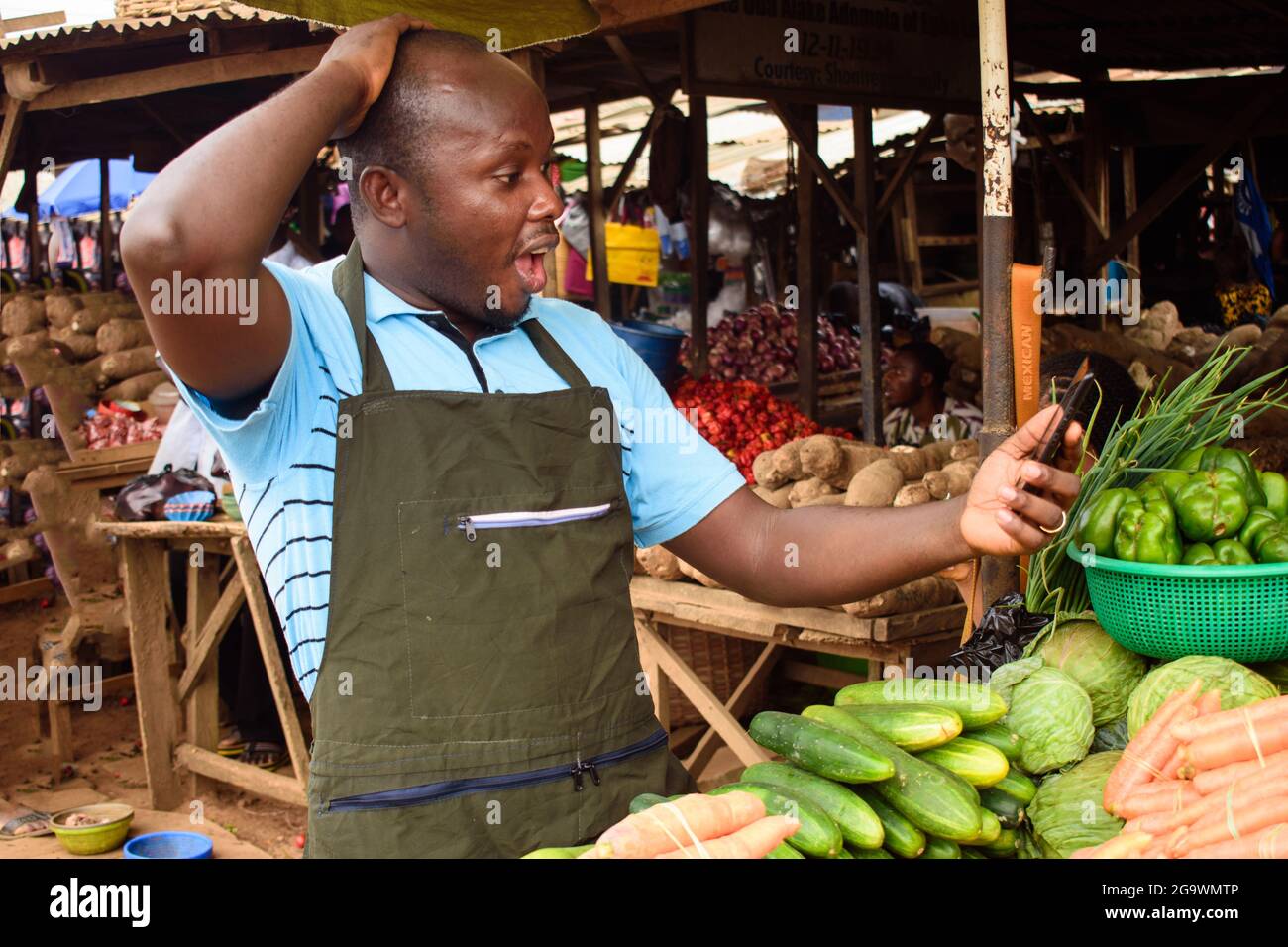 stock photo of male African grocery seller with apron, amazed as he ...
