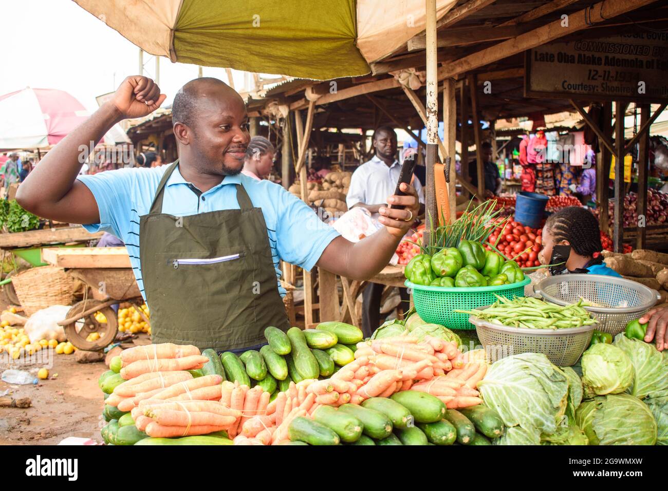 stock photo of male African grocery seller with apron, amazed as he ...