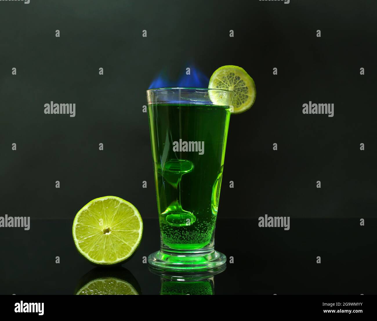 Flaming green cocktail on dark background Stock Photo - Alamy