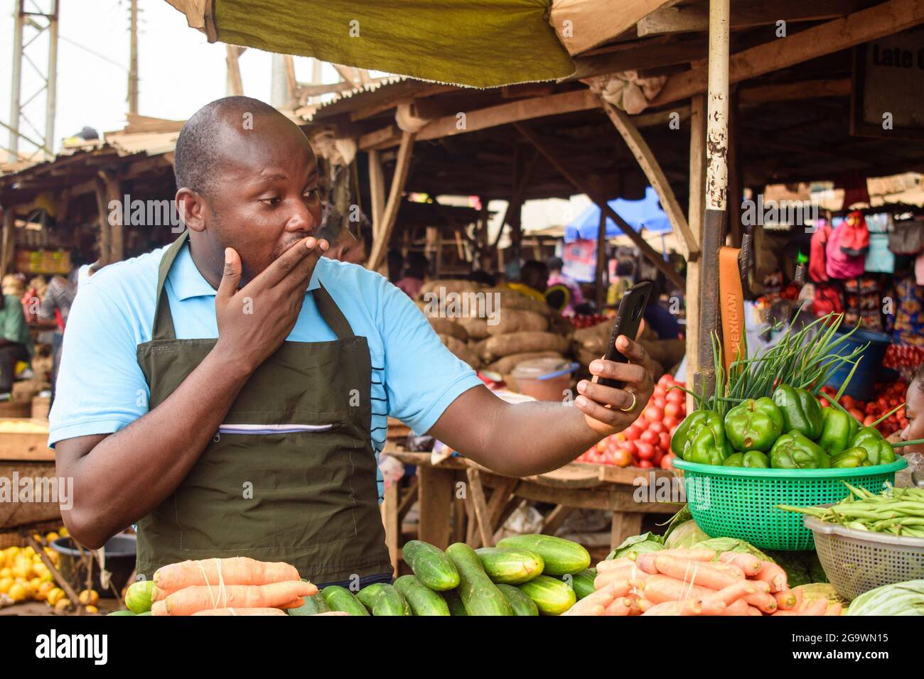 stock photo of male African grocery seller with apron, amazed as he ...