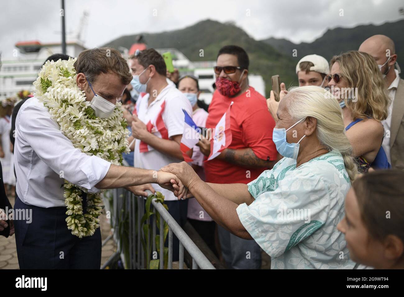 French President Emmanuel Macron (L) greets local residents as he ...