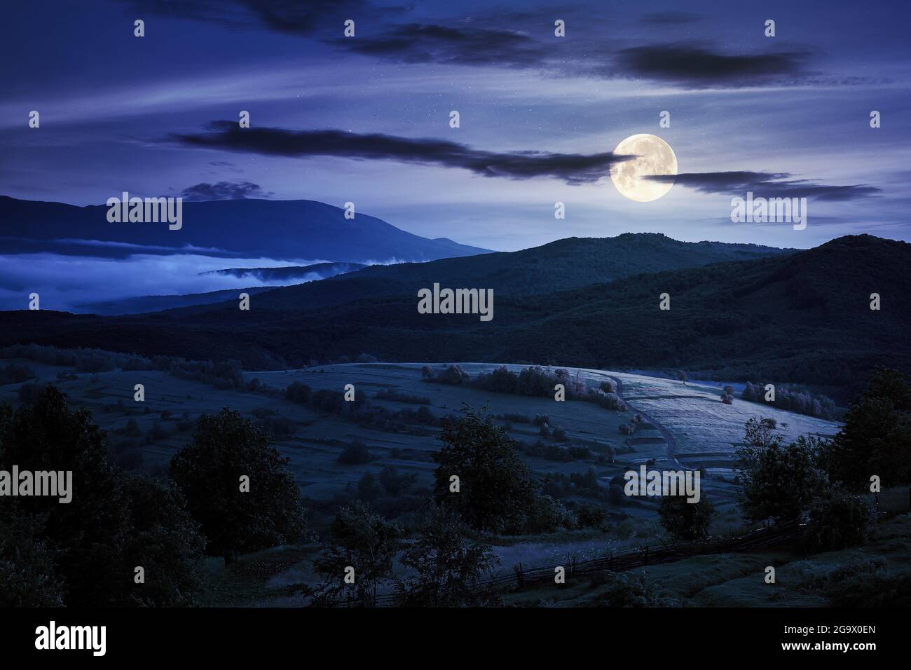mountainous countryside landscape at night. trees and agricultural ...