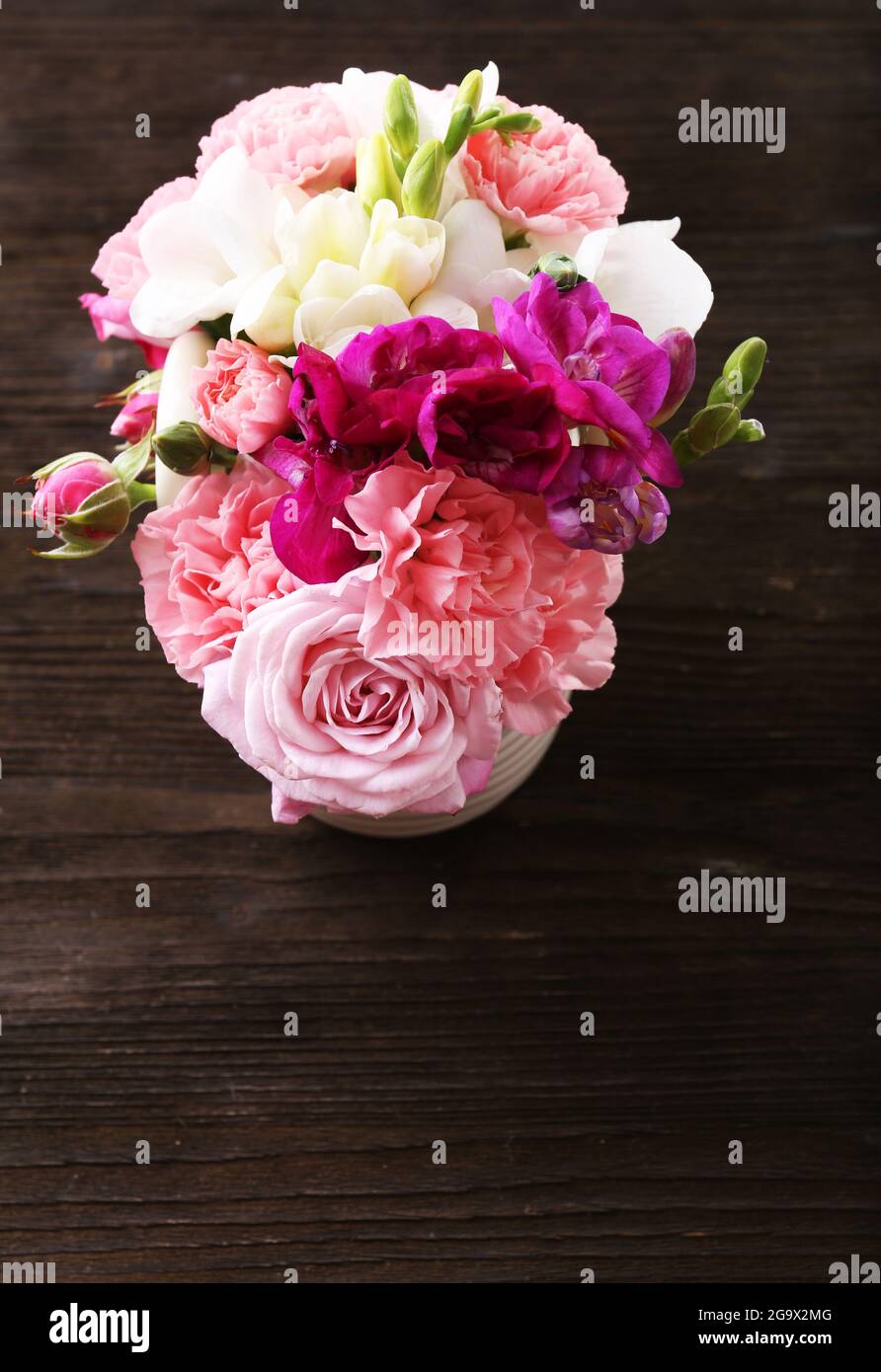 Beautiful spring flowers in pot on wooden background Stock Photo - Alamy
