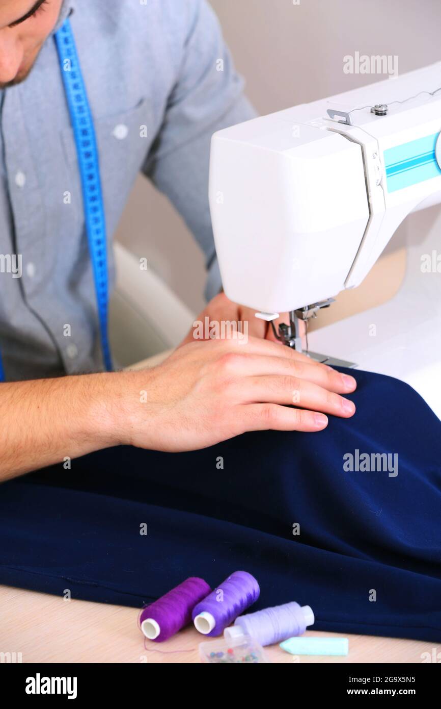 Man direct fabric in sewing machine Stock Photo - Alamy