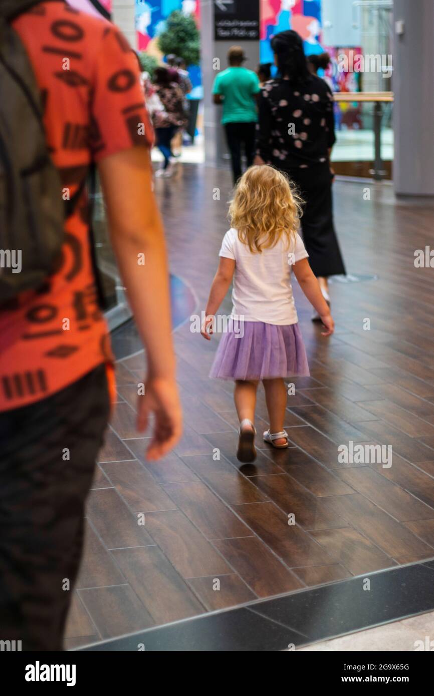 Shot of a little girl walking in the crowd Stock Photo - Alamy