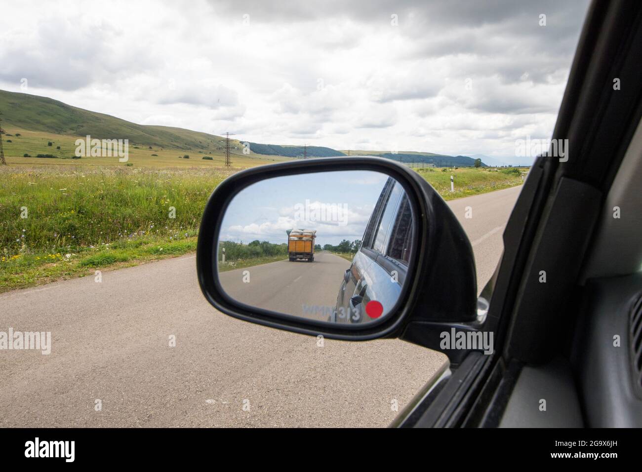 Car mirror and highway view, black car and nature landscape in Georgia ...