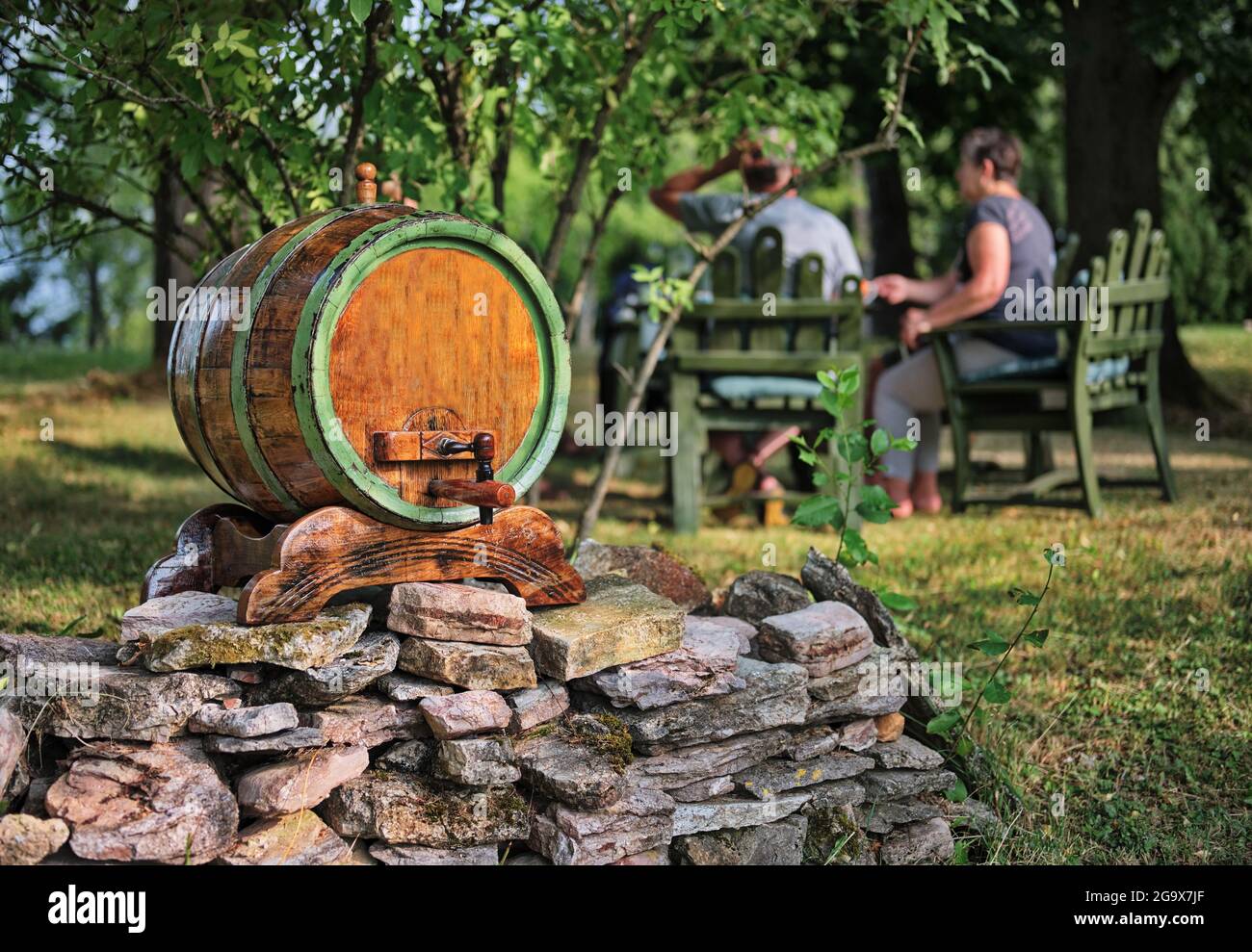 Barrel on stone wall in backyard Stock Photo - Alamy