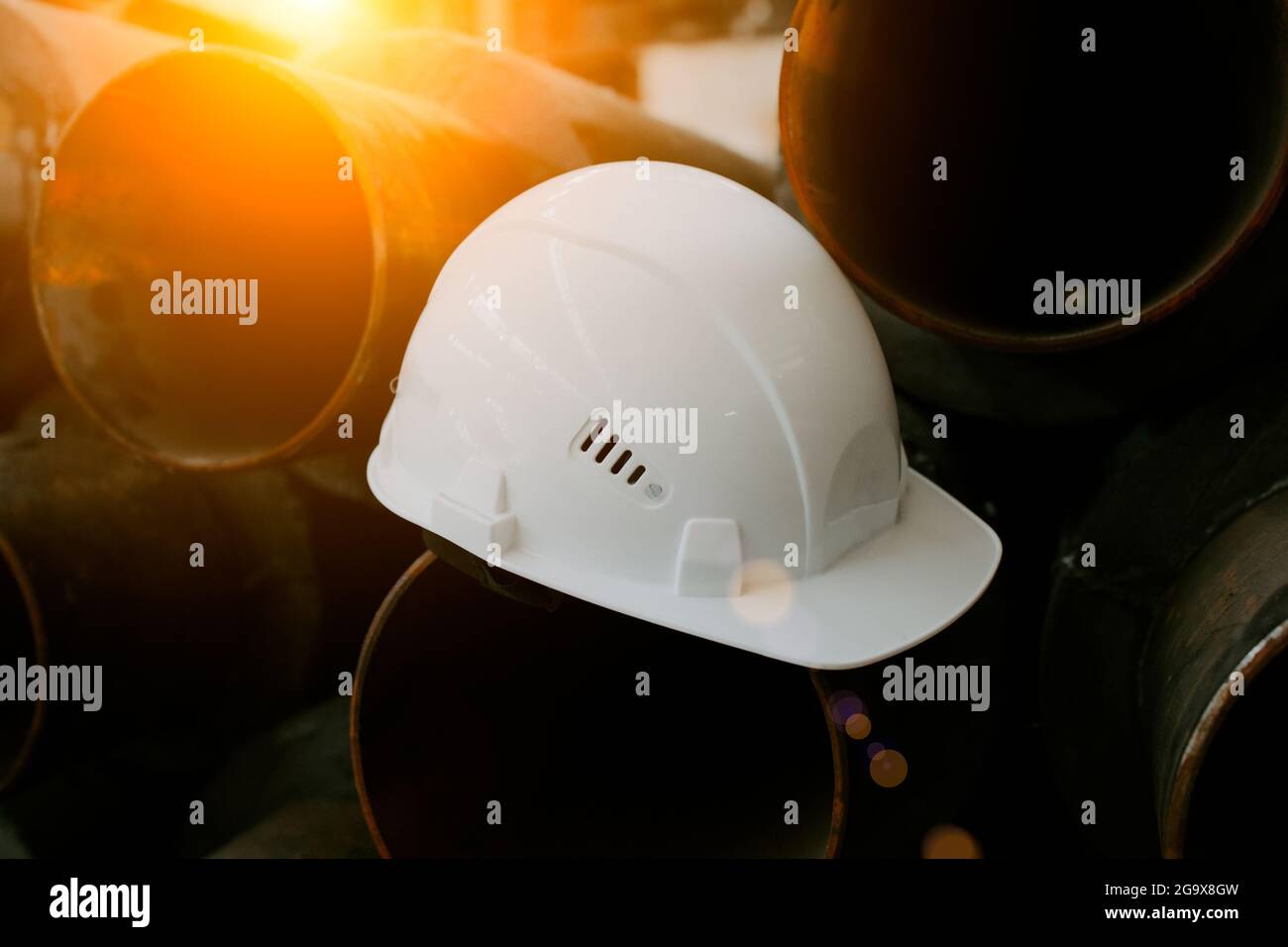 white construction helmet is lying on the pipe Stock Photo - Alamy