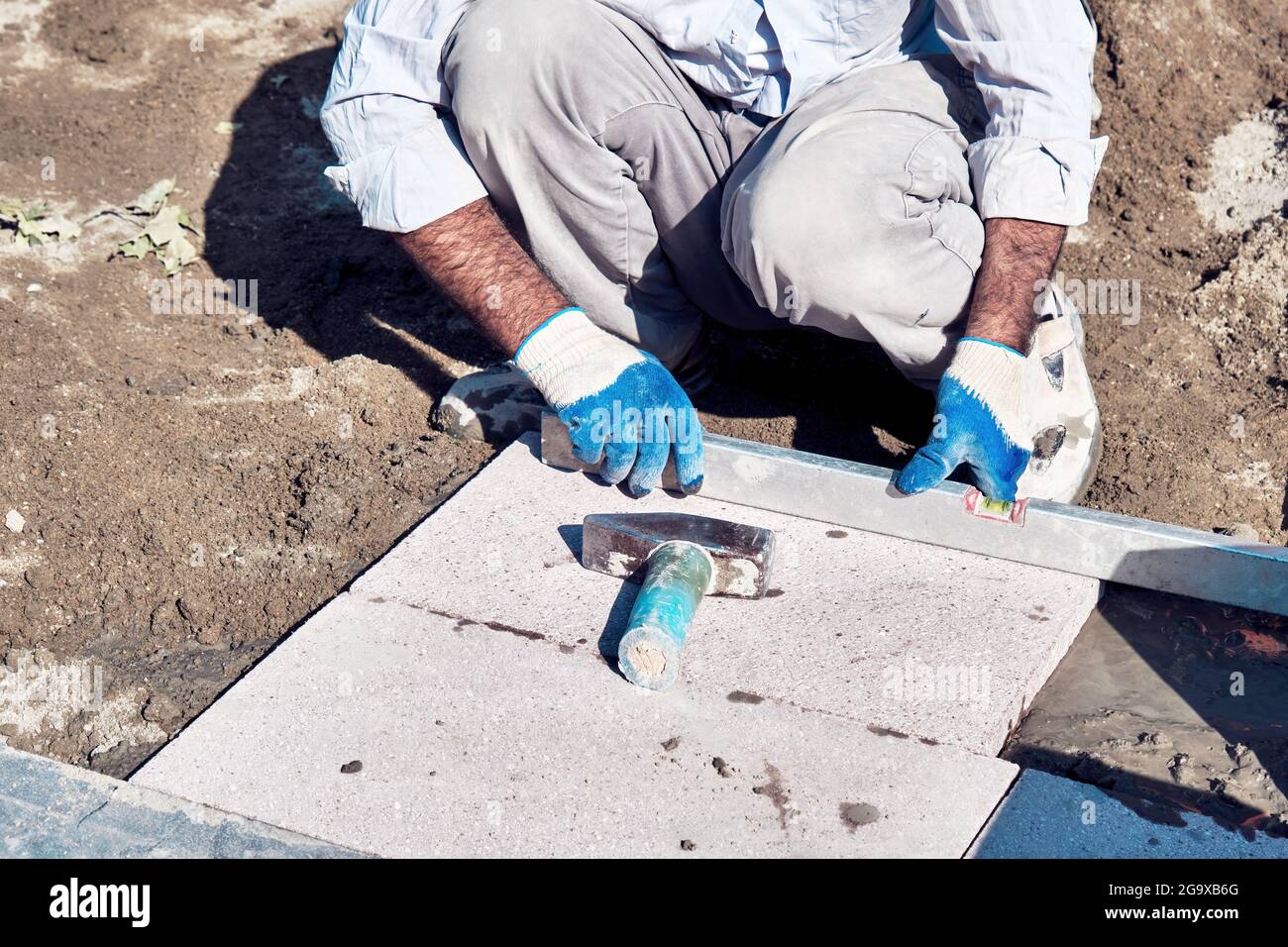 Turkish pavement construction worker using a water level tool for ...