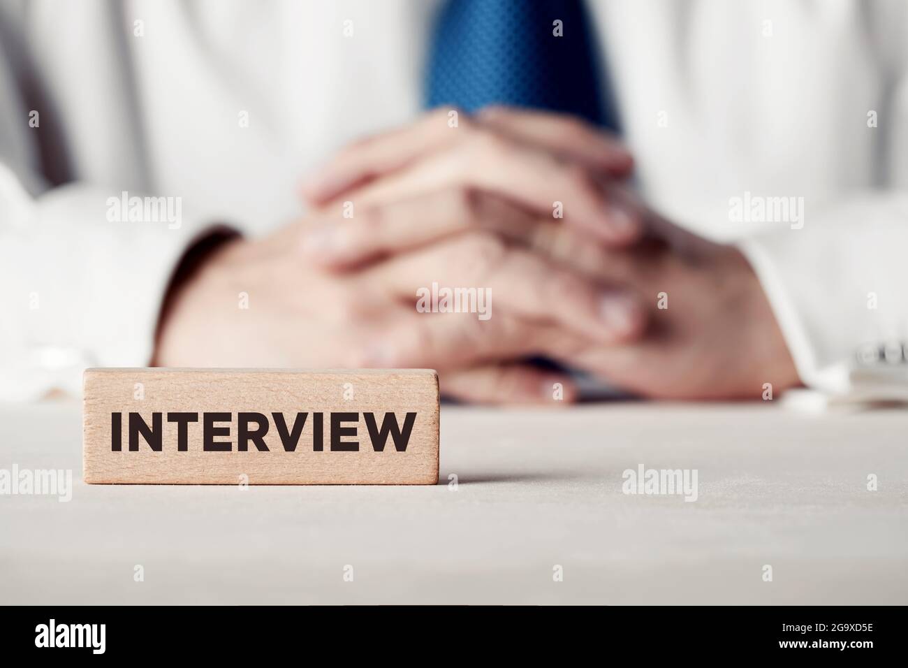 The word interview written on a wooden block in front of a businessman ...