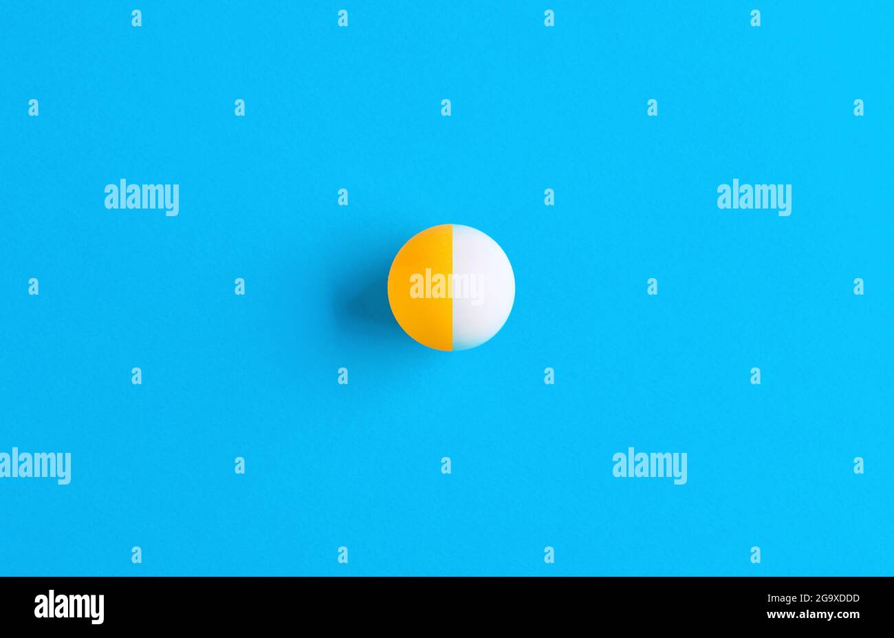 Ball halved into two different colors on blue background. Dissociative ...