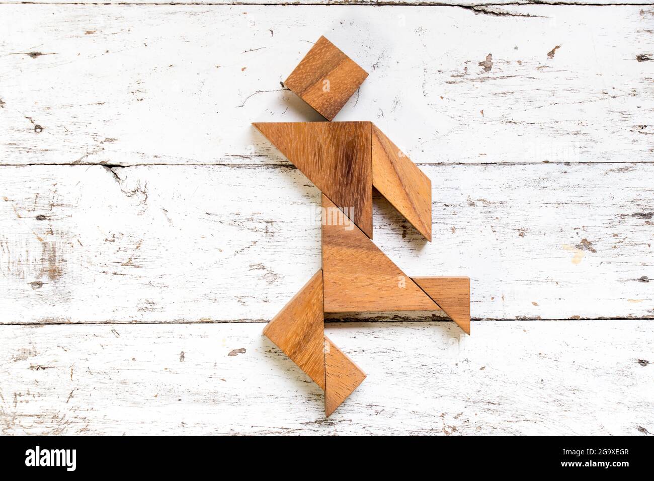 Tangram puzzle in happy running man shape on old white wood background ...
