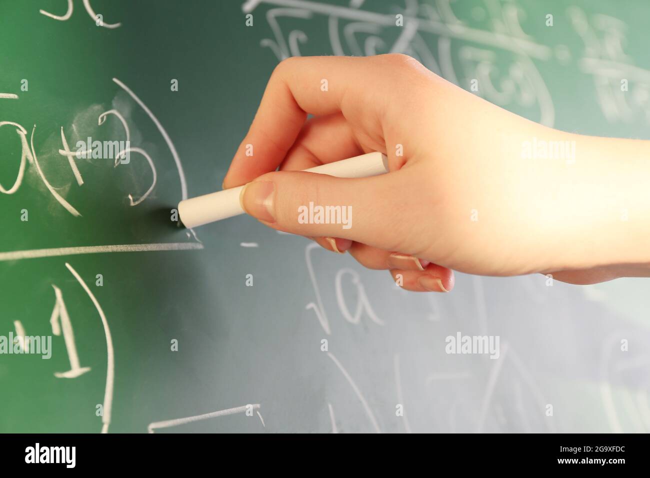Teacher hand writing formulas on blackboard background Stock Photo - Alamy